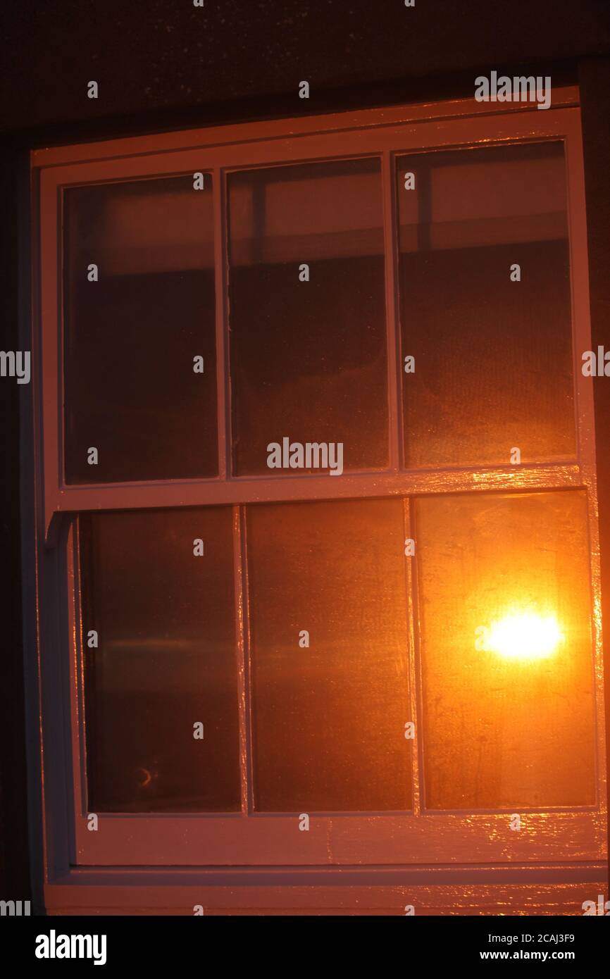 Orange sunset reflected in cottage window Stock Photo - Alamy