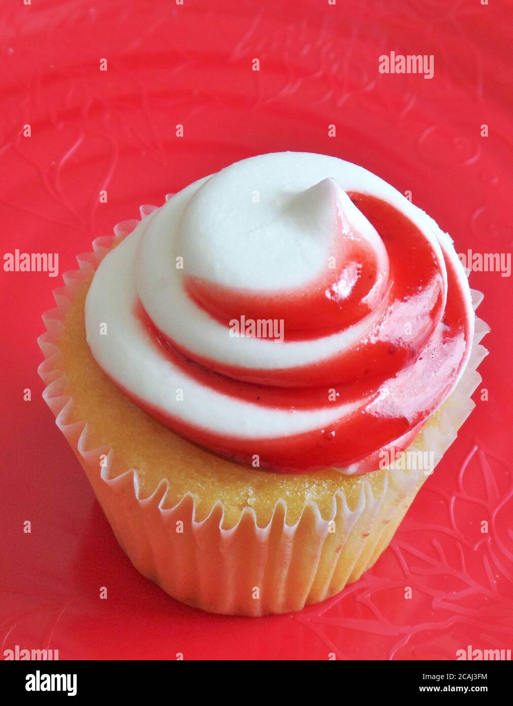A cupcake with red and white frosting Stock Photo - Alamy