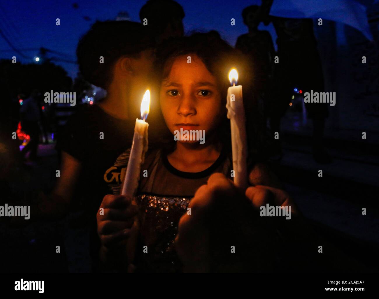 Gaza, Palestine. 06th Aug, 2020. A Palestinian girl holds lit candles ...