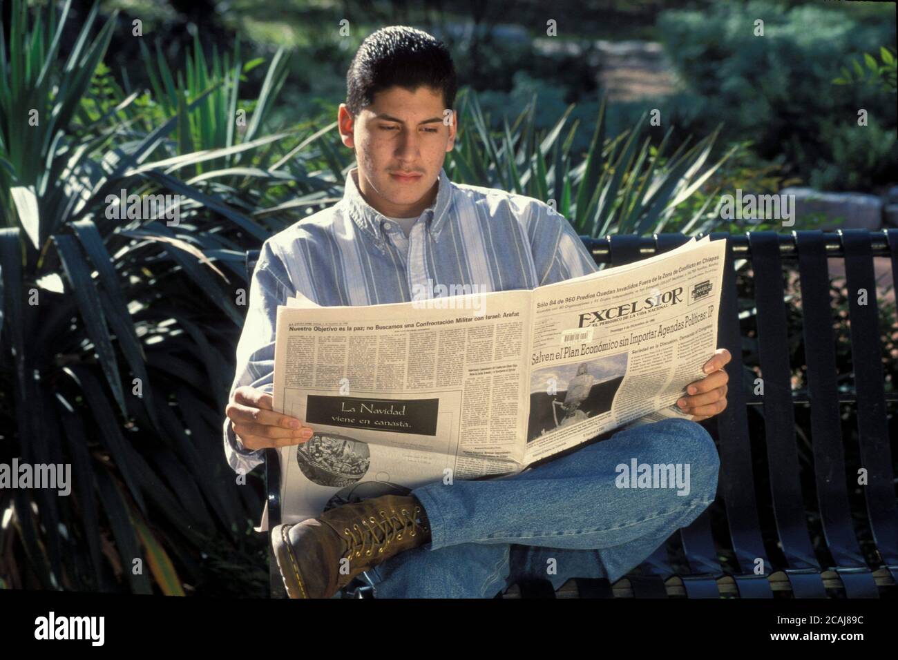 Hispanic teenage male, 18/, reads Spanish-Language newspaper on public ...
