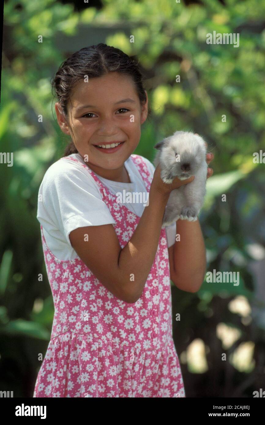 Austin Texas USA,1995: 9-year-old Hispanic girl gently holds her pet ...