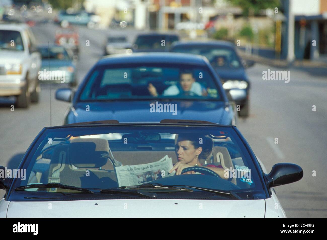 Bad Driving Habits: woman reads newspaper during commute while driver ...