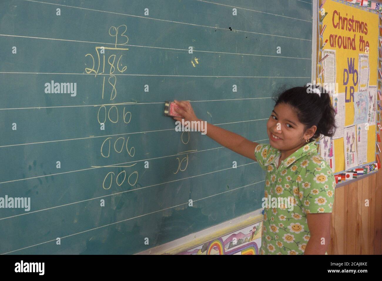 Hispanic 5th grade girl explains her long-division problem on ...