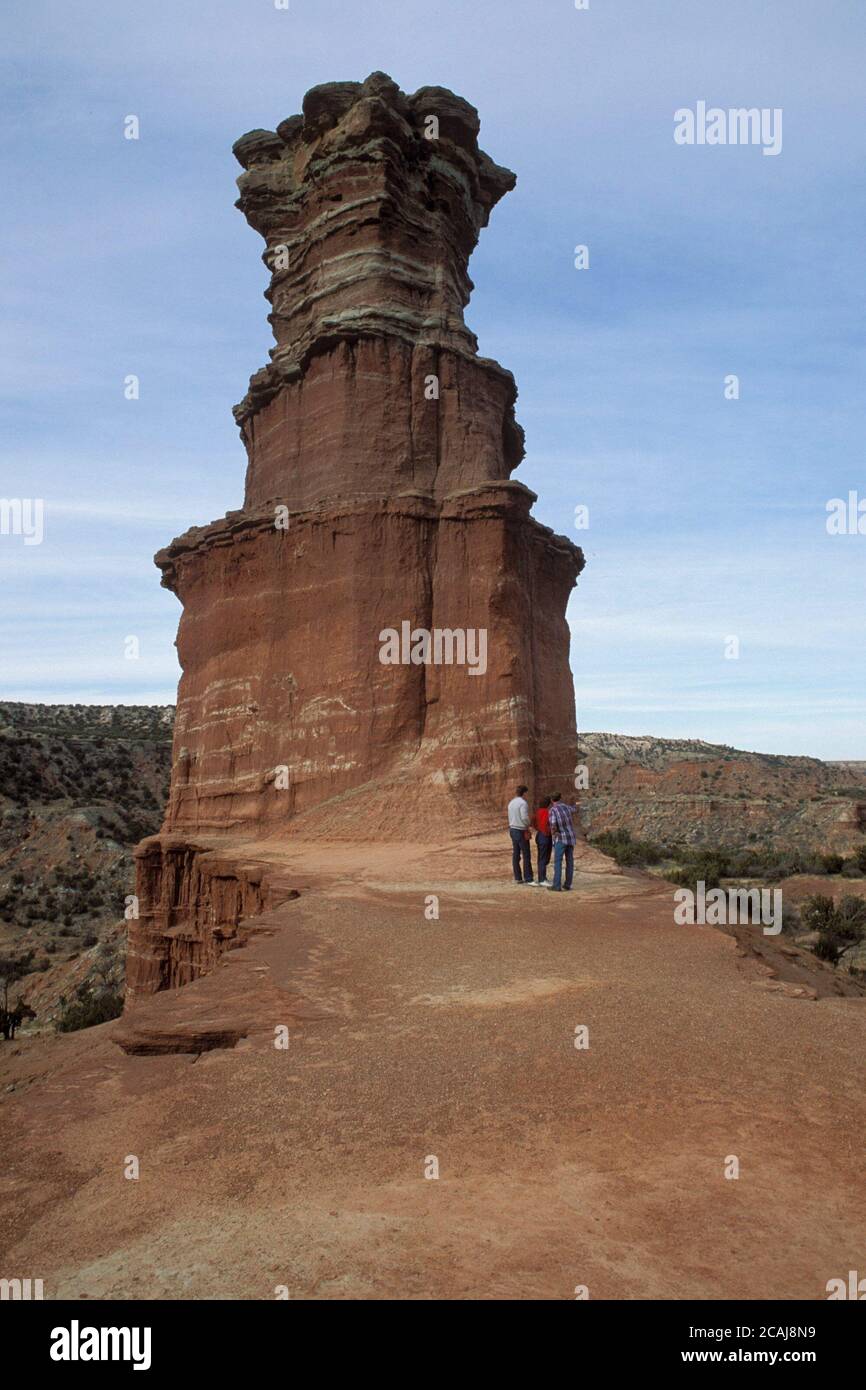 Three members of Hispanic family visit large rock formation called "The ...