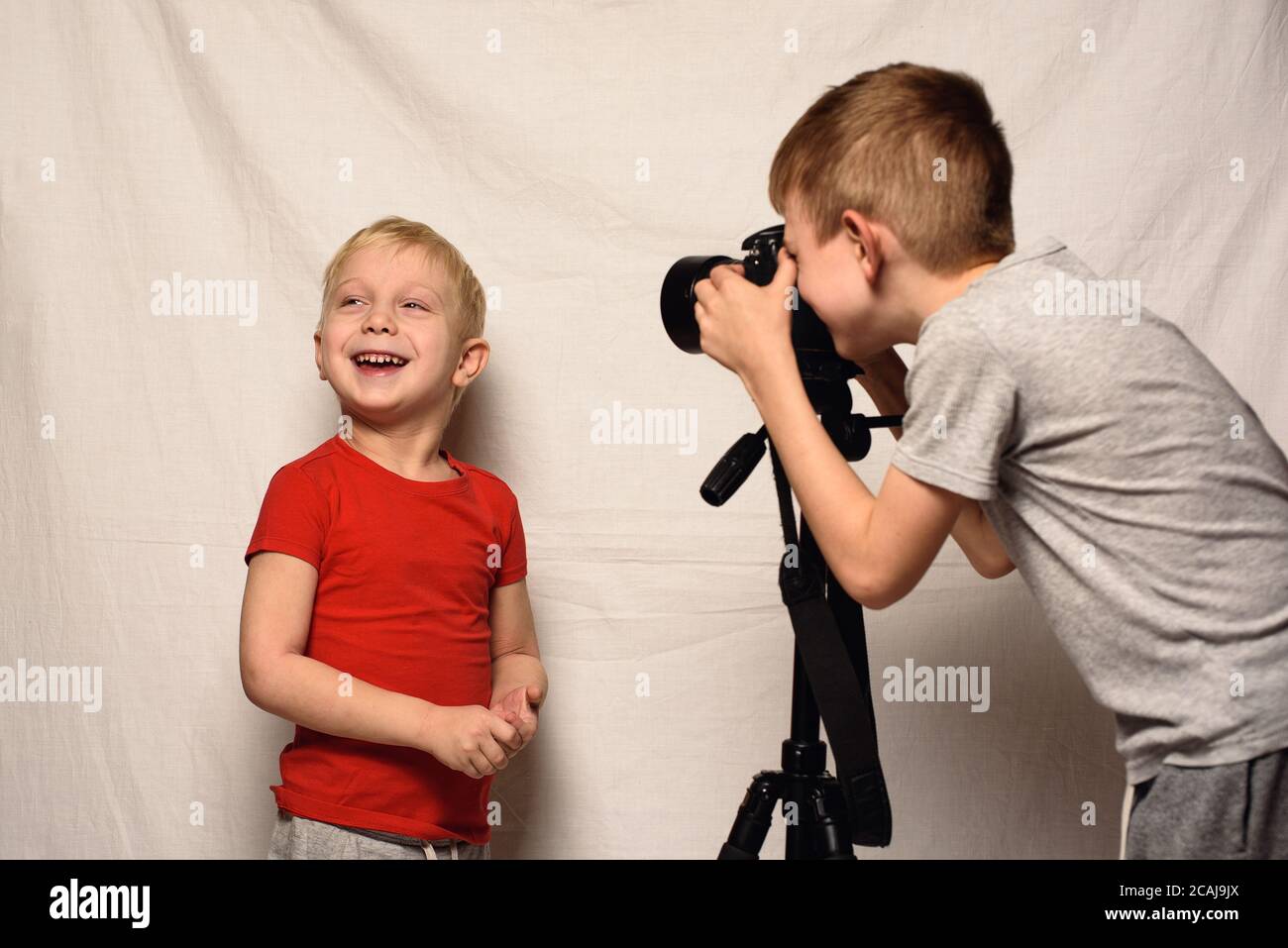 Boys are photographing each other with a SLR camera. Home studio. Young ...