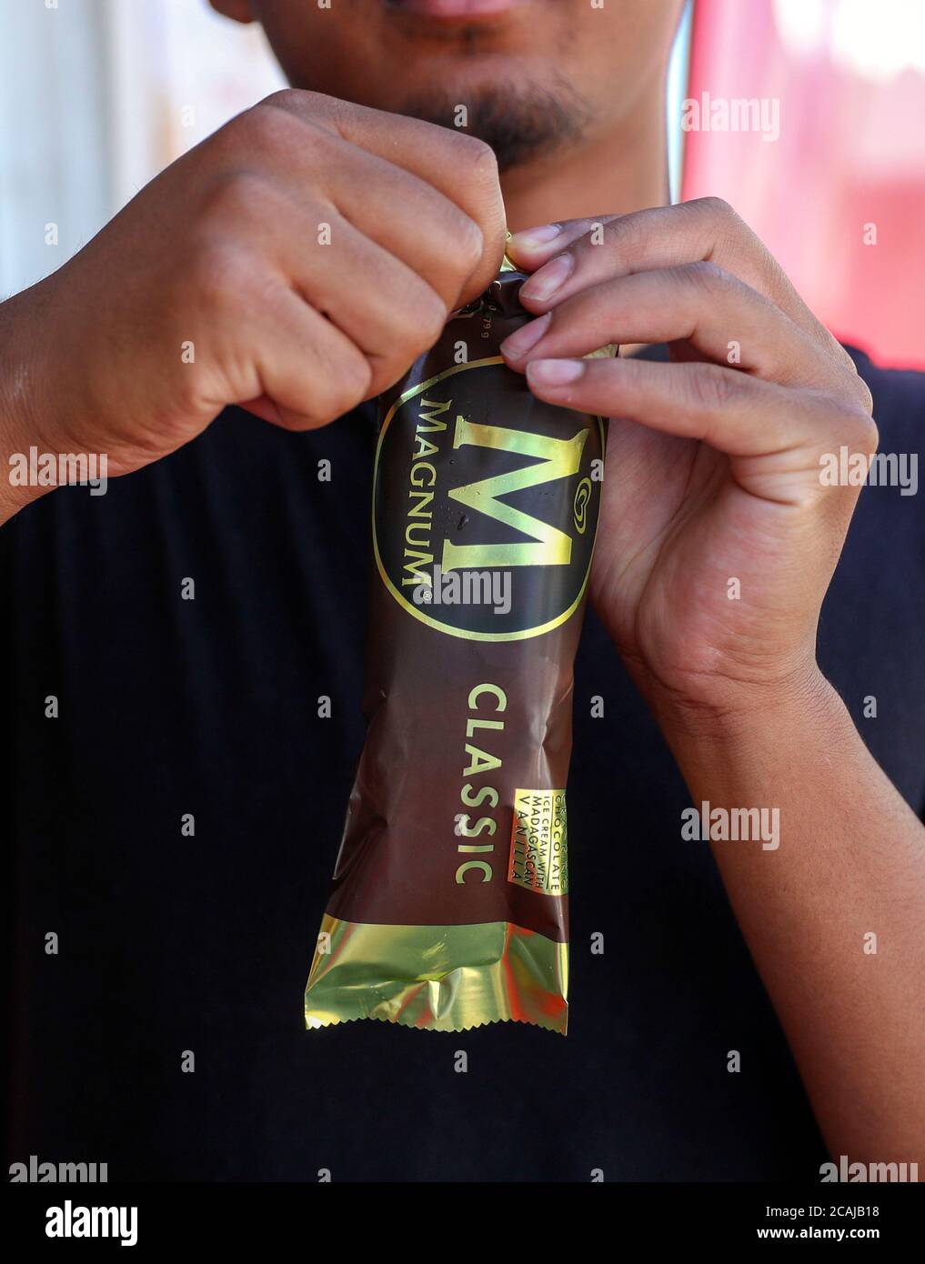 A man unwraps a Magnum ice cream as a new survey from YouGov has ...