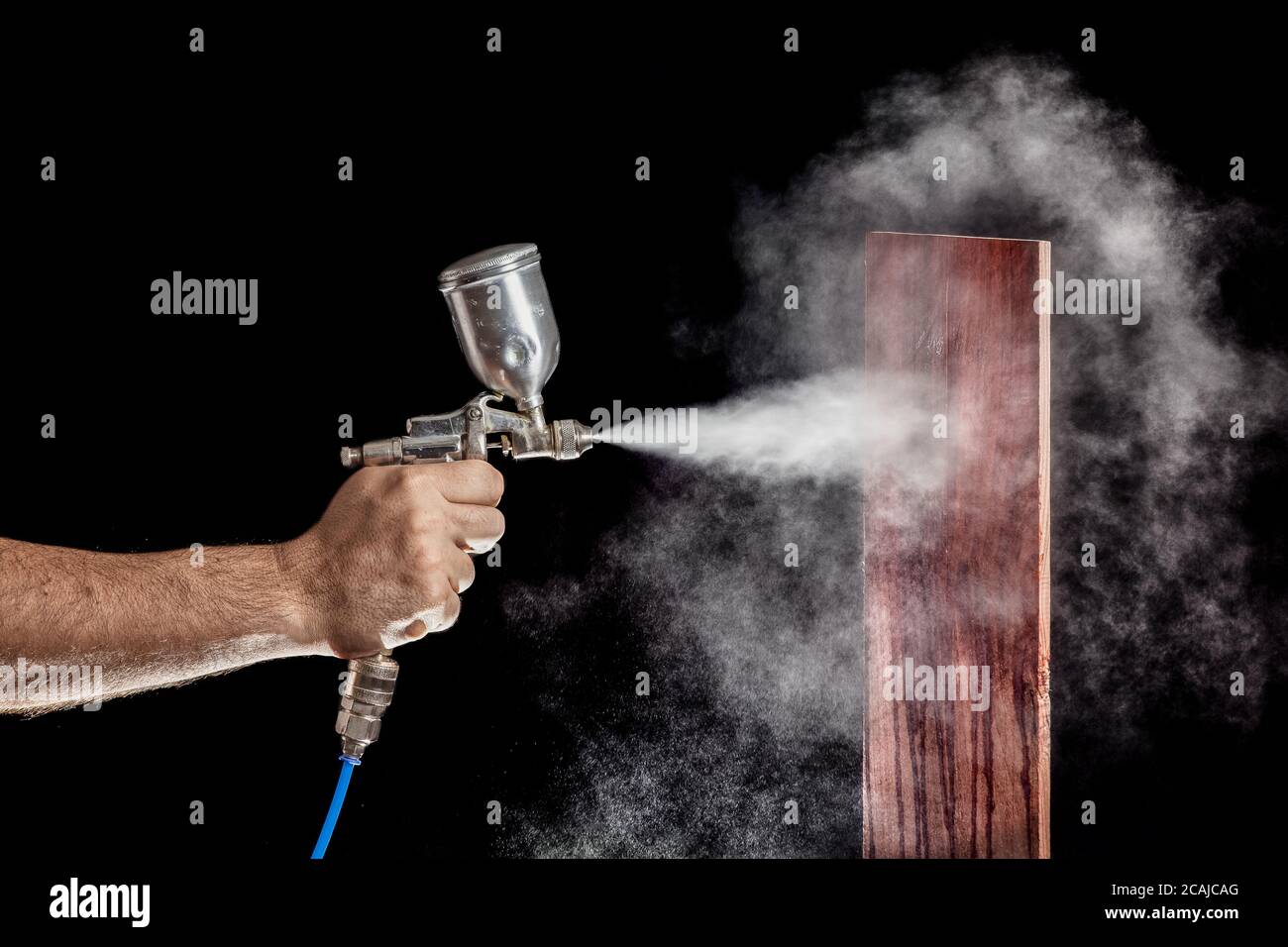 Close up of a spray paint gun with brown background Stock Photo - Alamy