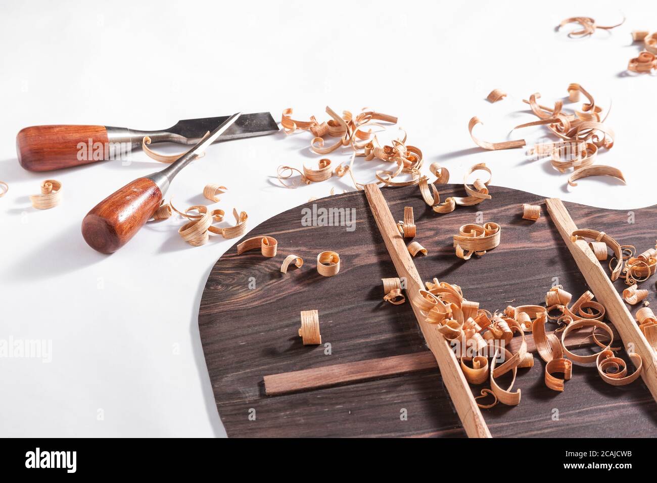 Back of guitar under construction with chisels and wood chips Stock ...