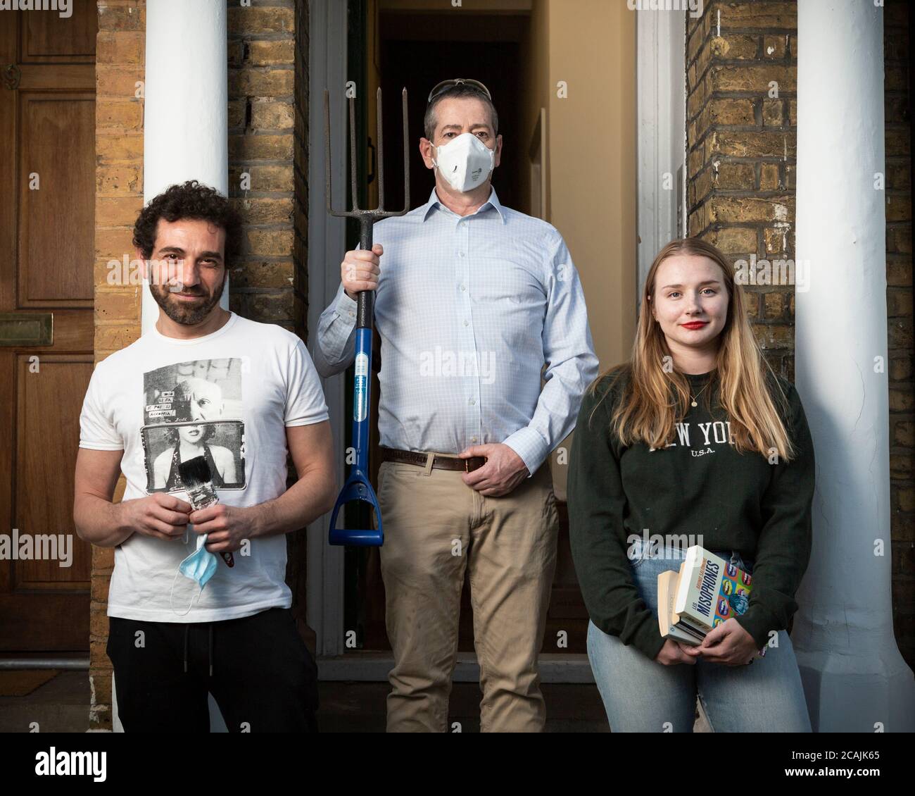 Three people standing on the doorstep of their homes during the COVID ...