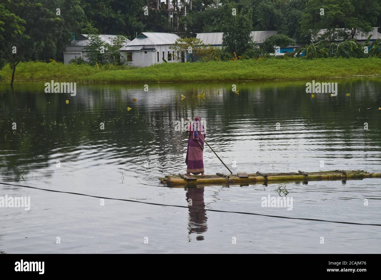 Village woman ride on makeshift raft made of banana trees in the flood ...