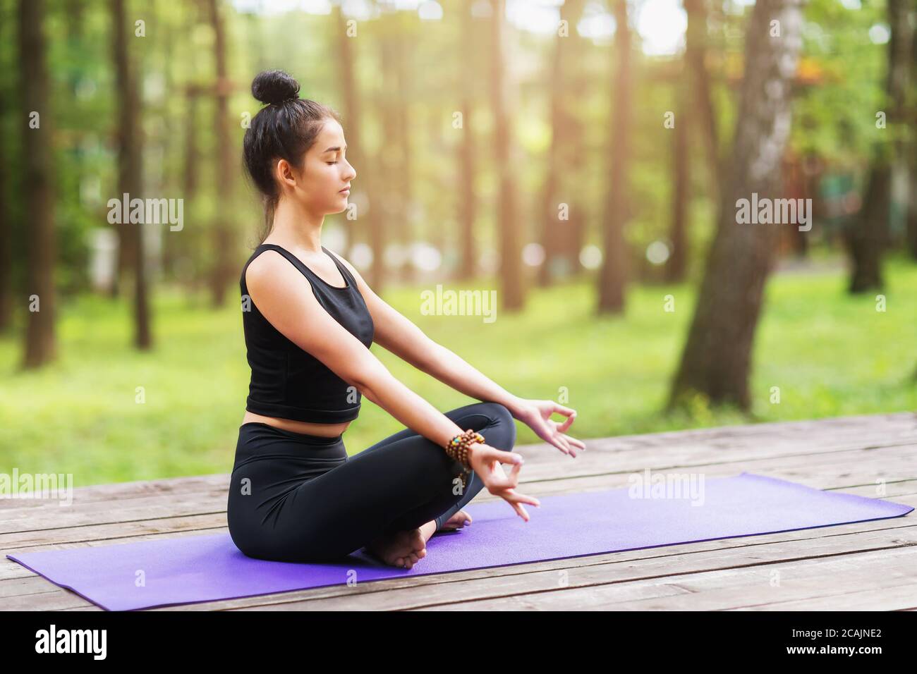 Female trainer in sportswear, practicing yoga asanas, performs the ...