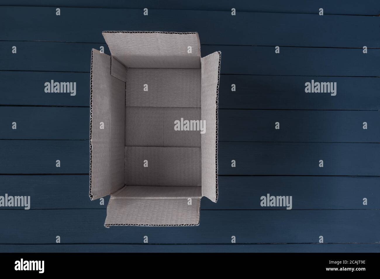 Empty open cardboard box on black wooden background. Delivery concept ...