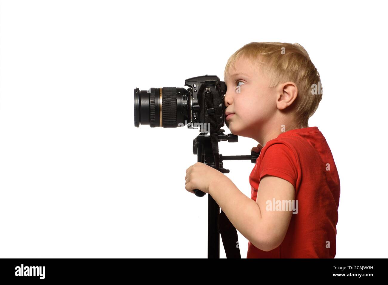 Blond boy takes pictures with a SLR camera. Side view. White background ...