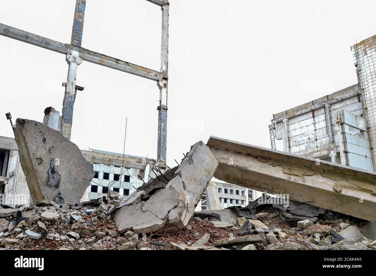Broken concrete slabs and beams on the background of a destroyed ...