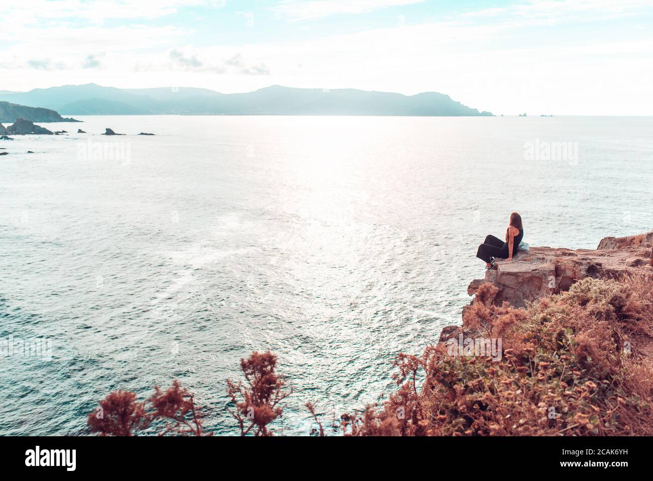 Woman contemplating the ocean from a cliff with plenty of copy space ...