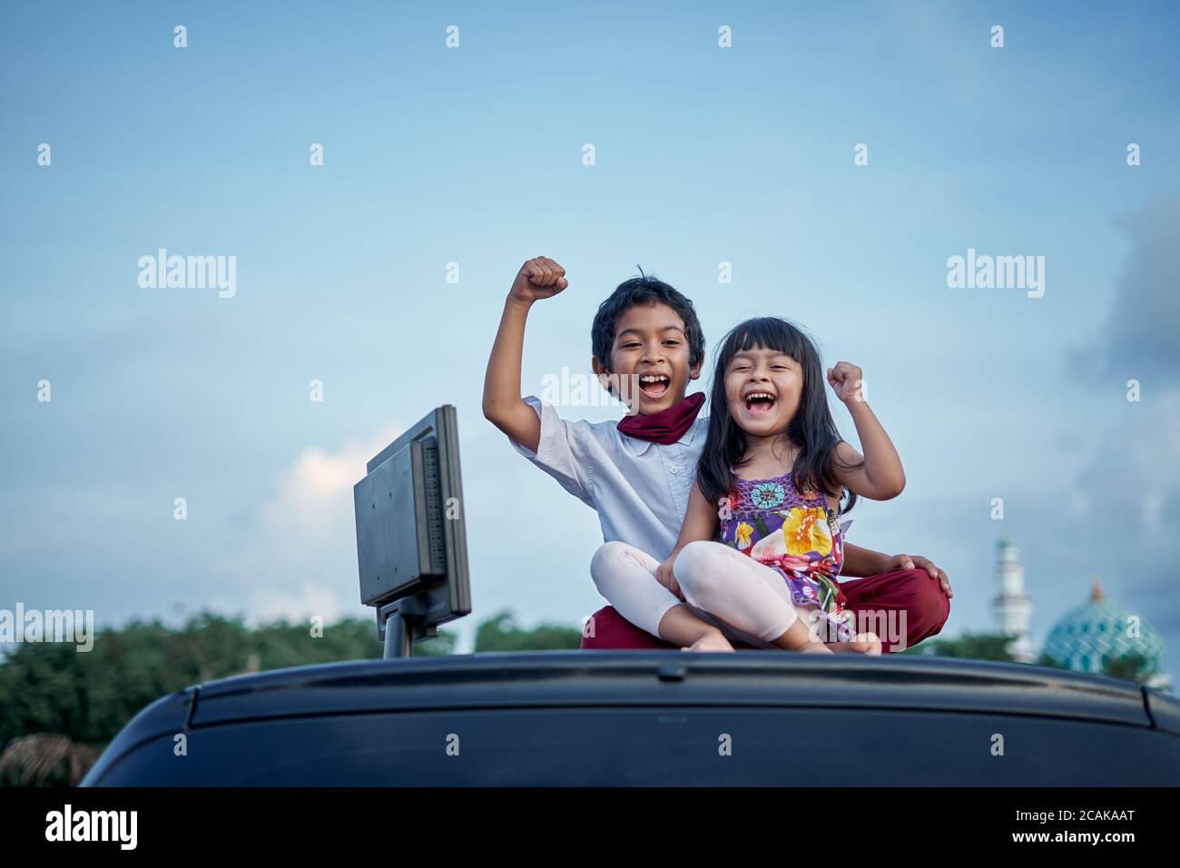Boy and little girl fist pumps while working on a homework using ...