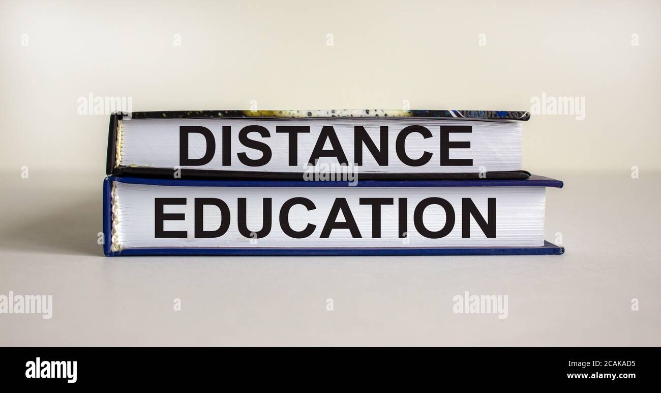 Books with text 'distance education' on beautiful white table. White ...