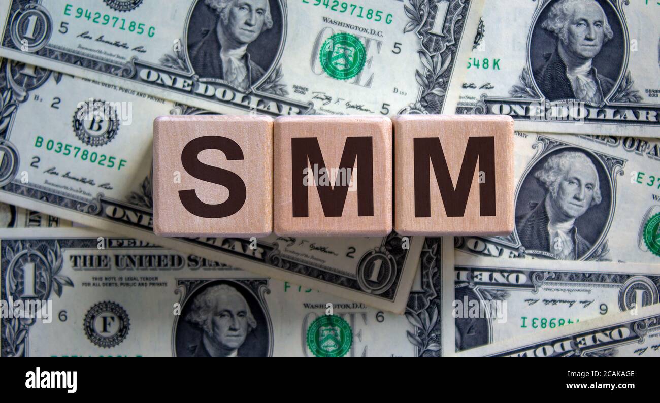 Concept word 'SMM' on cubes on a beautiful background from dollar bills ...