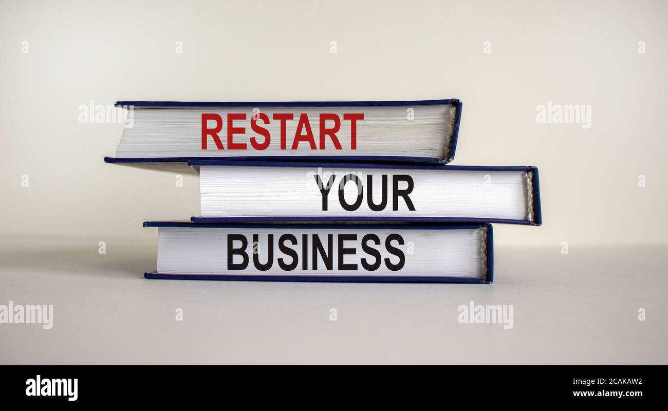Books with text 'restart your business' on beautiful white table. White ...