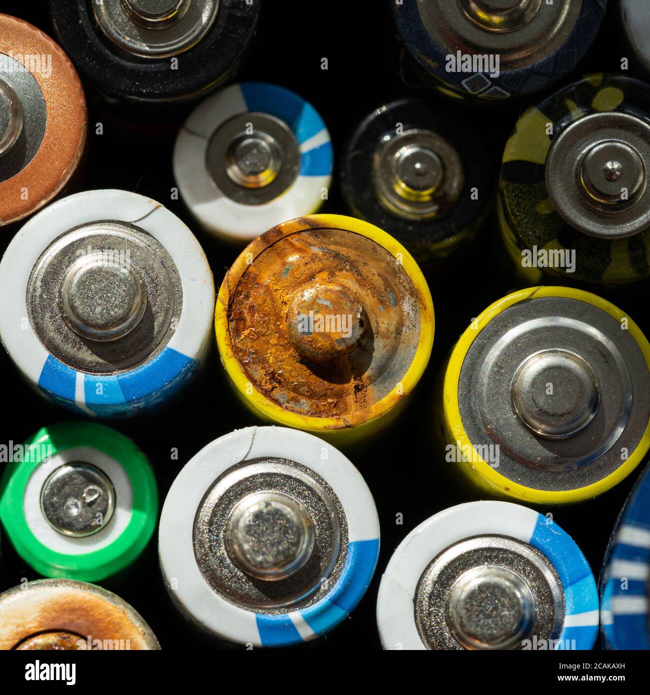 Close up of positive ends of discharged batteries of different sizes ...