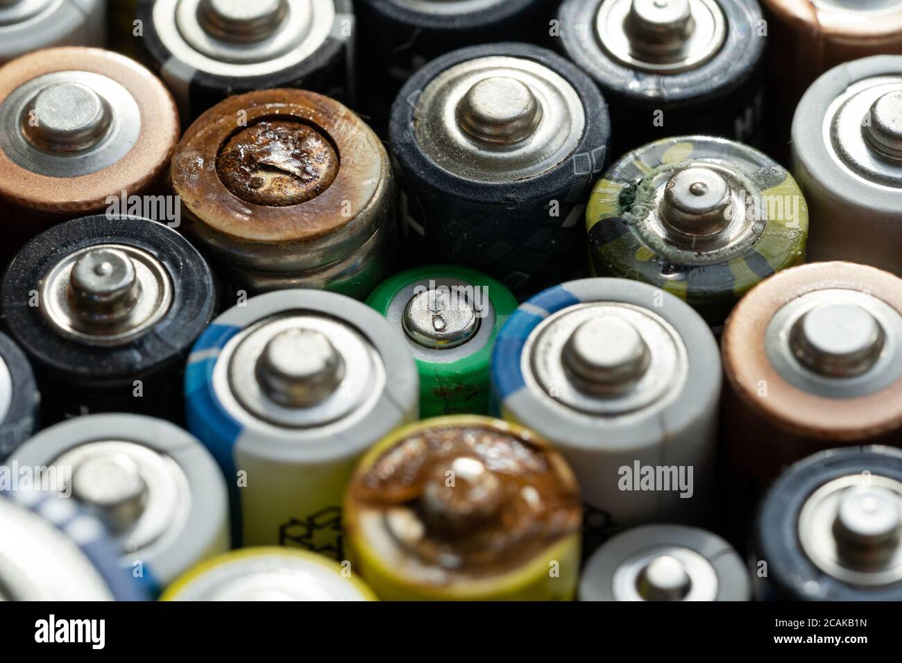 Close up of positive ends of discharged batteries of different sizes ...