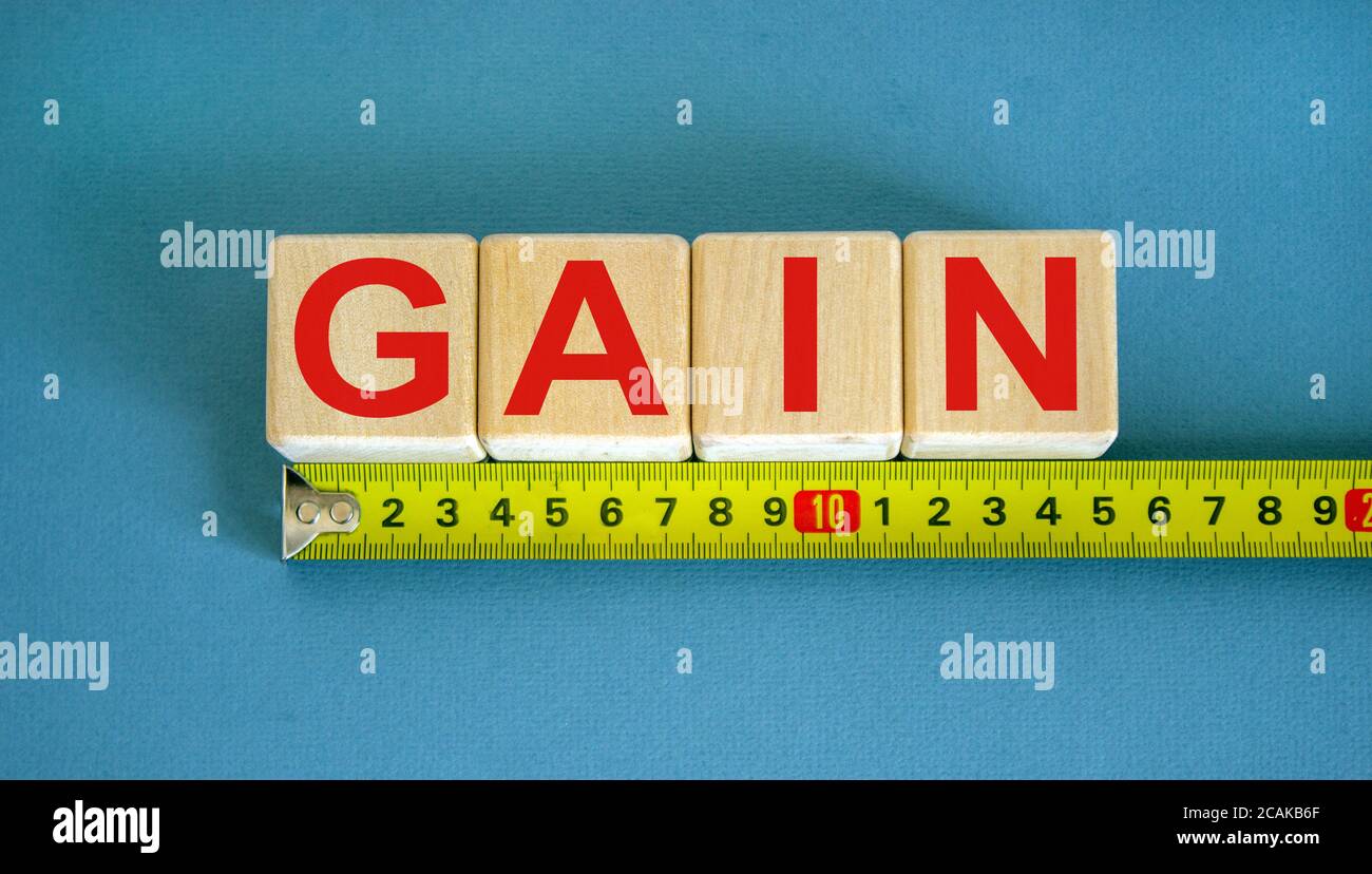 'Gain' word on cubes arranged behind the ruler on beautiful blue ...