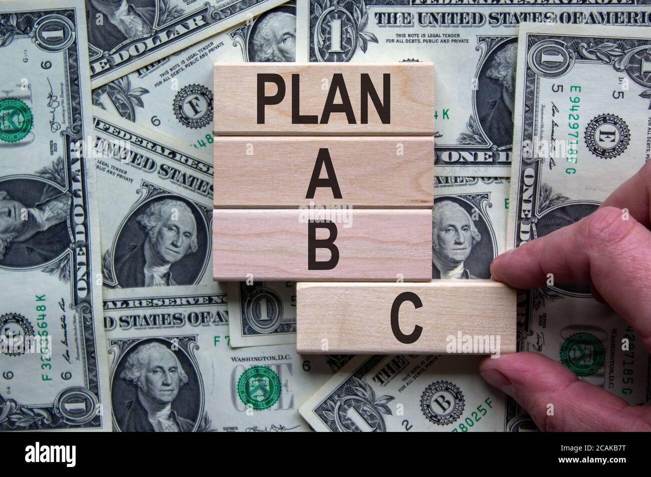Wooden blocks form the words 'plan, A, B, C,' on background from dollar ...