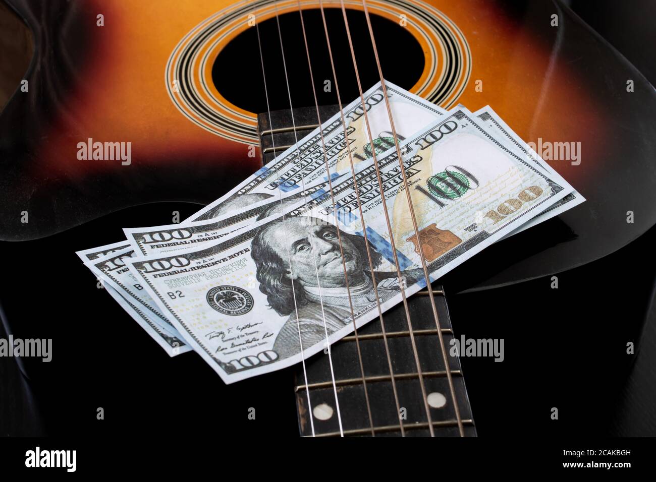 Dollar bills on an acoustic guitar closeup Stock Photo - Alamy