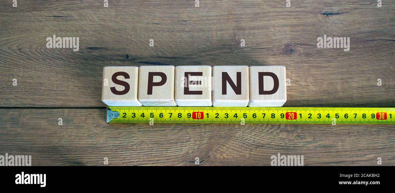'Spend' word on cubes arranged behind the ruler on beautiful white ...
