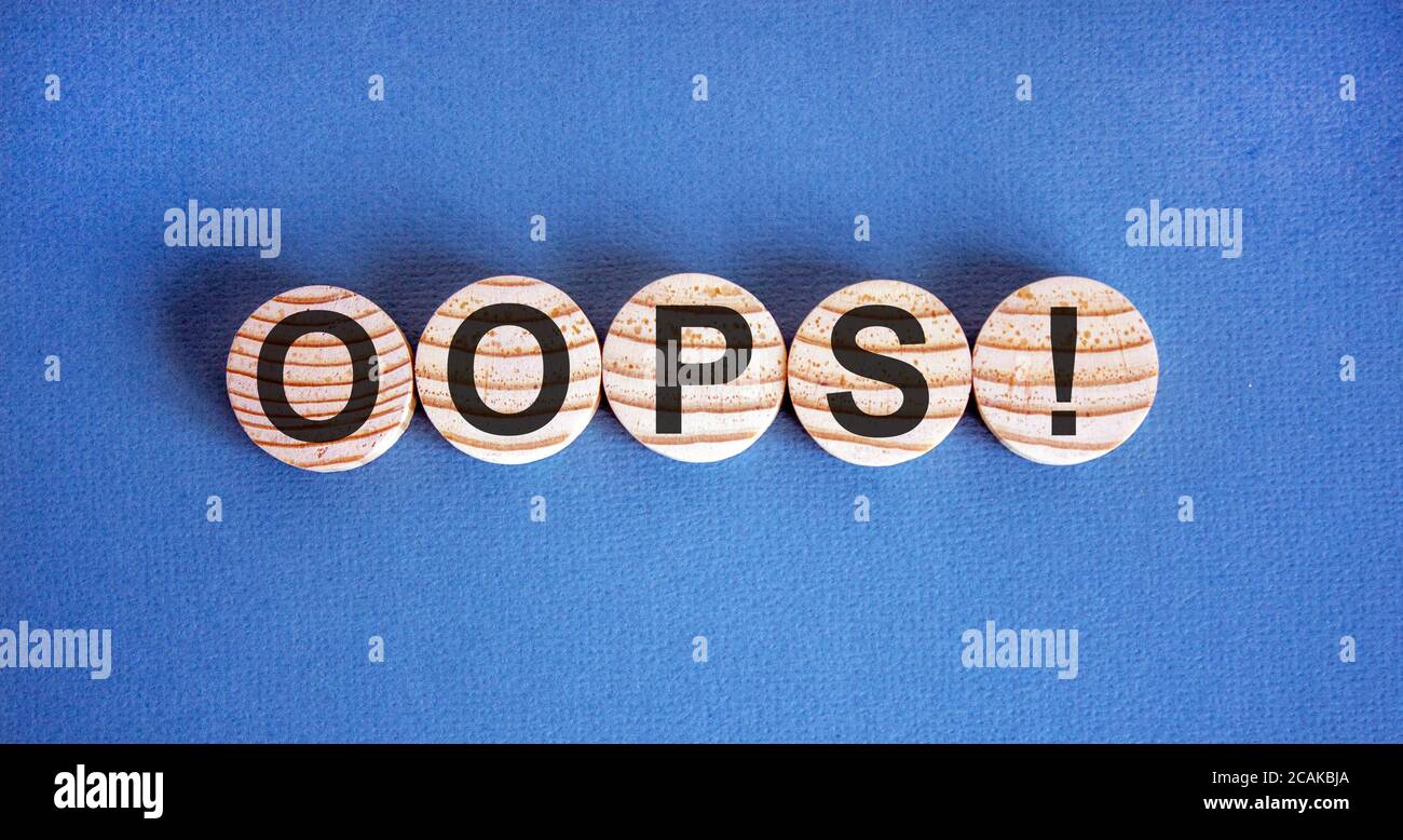 Oops sign on wooden cut circles. Beautiful blue background, copy space ...