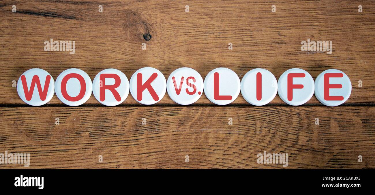 The words 'work vs life' on white circles on wooden table. Beautiful ...