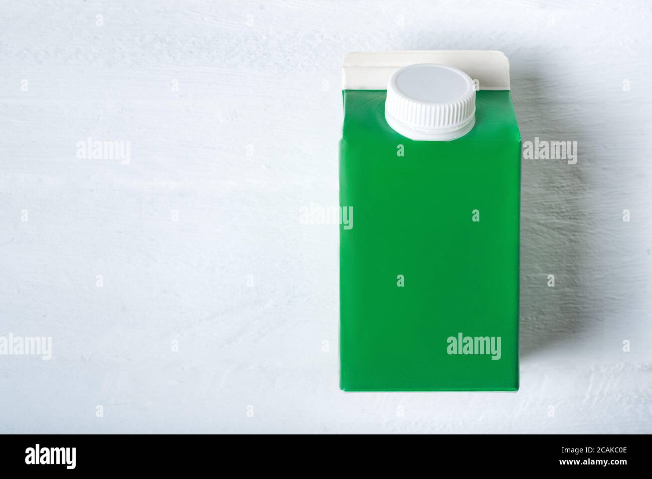 Green carton box or packaging of tetra pack with a cap. White ...