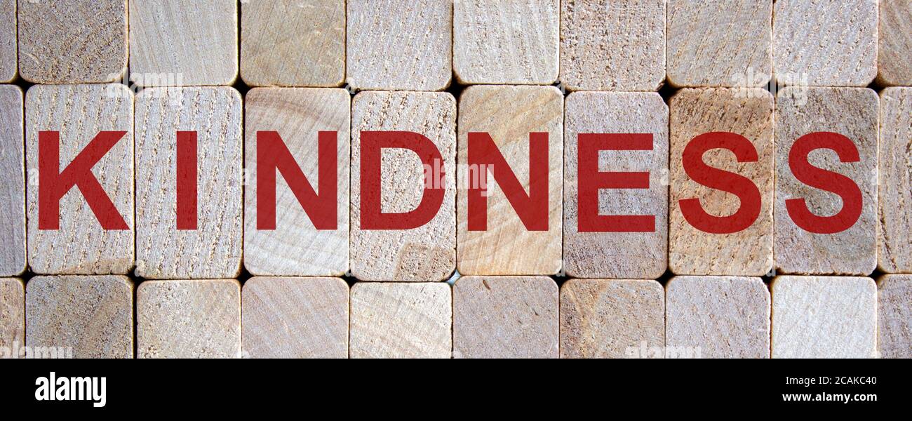 Wooden blocks form the word 'kindness'. Beautiful wooden background ...