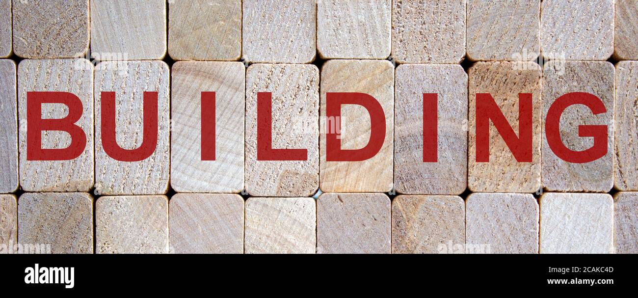 Wooden blocks form the word 'building'. Beautiful wooden background ...