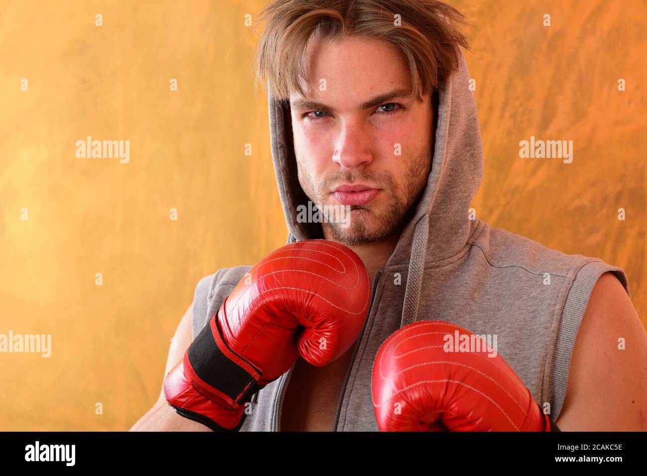Sports and fight concept. Man with messy hair on orange texture ...