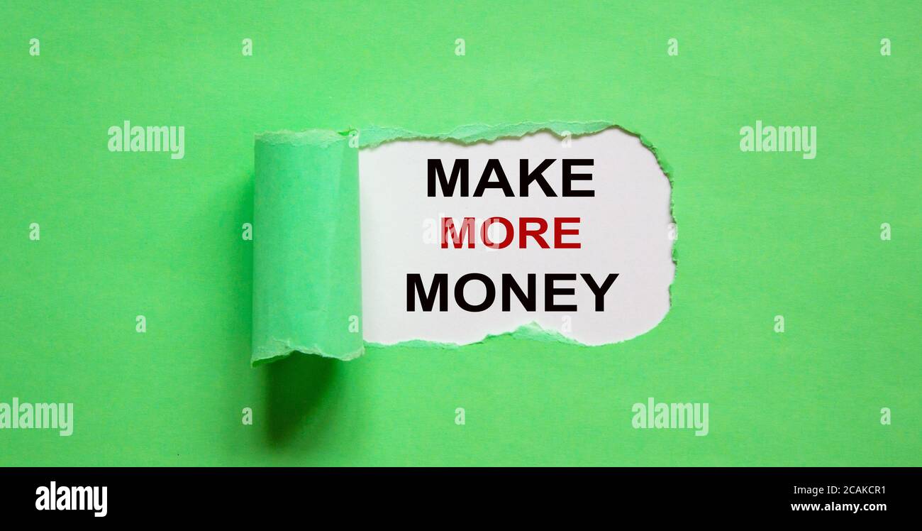 The text 'make more money' appearing behind torn green paper Stock ...