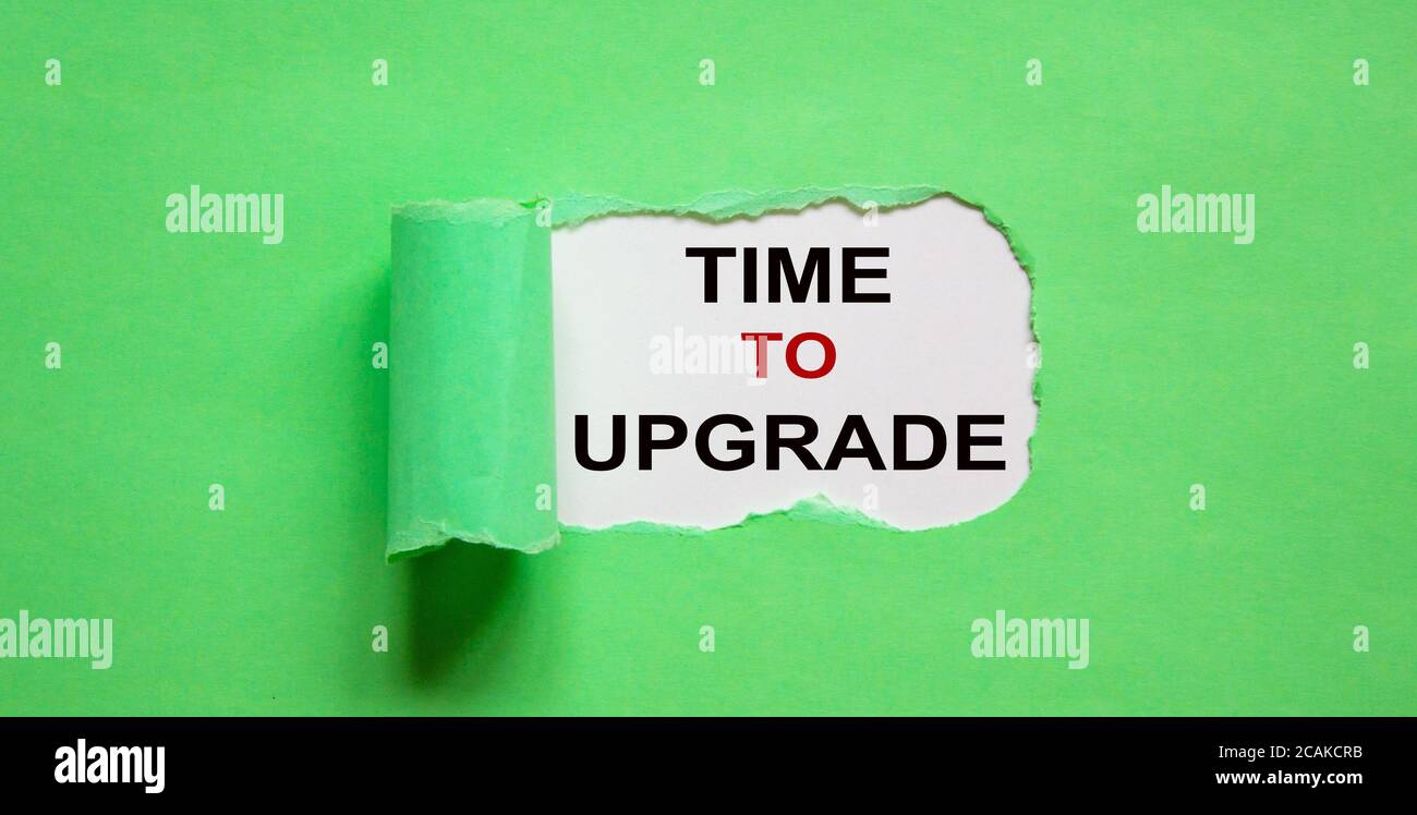 The text 'time to upgrade' appearing behind torn green paper Stock ...