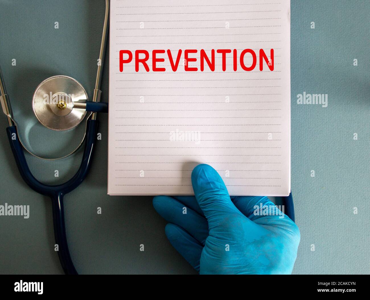 Hand in blue glove, white card with word prevention and stethoscope ...