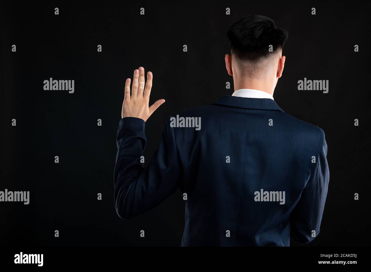 Back view of business man wearing blue business suit and tie taking ...