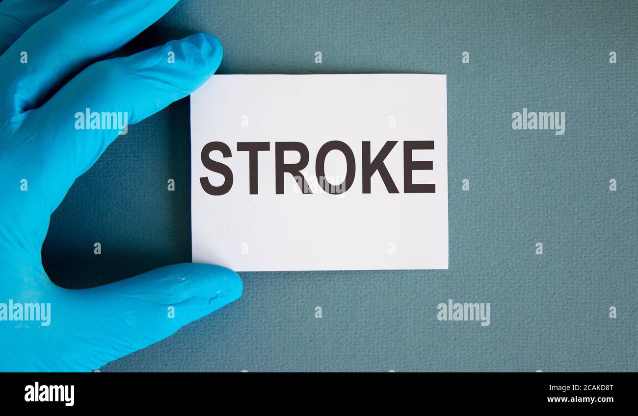 Hand in blue glove with white card. Concept word stroke Stock Photo - Alamy