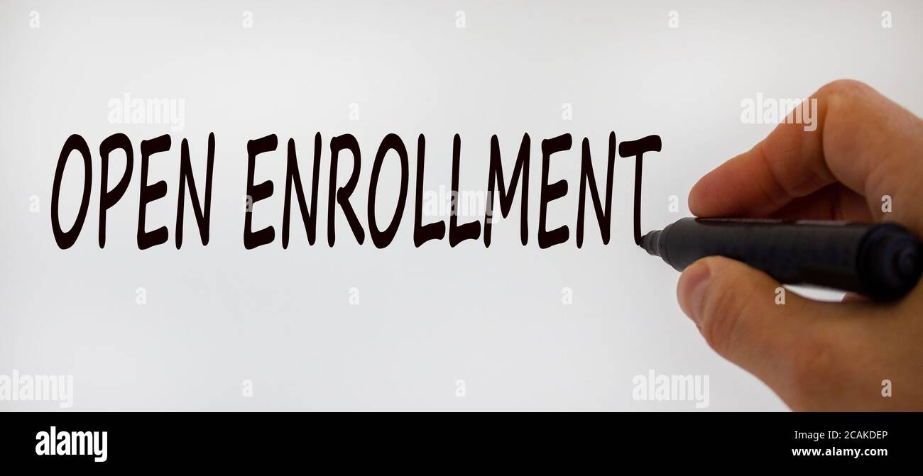 Hand writing 'open enrollment', isolated on beautiful white background ...