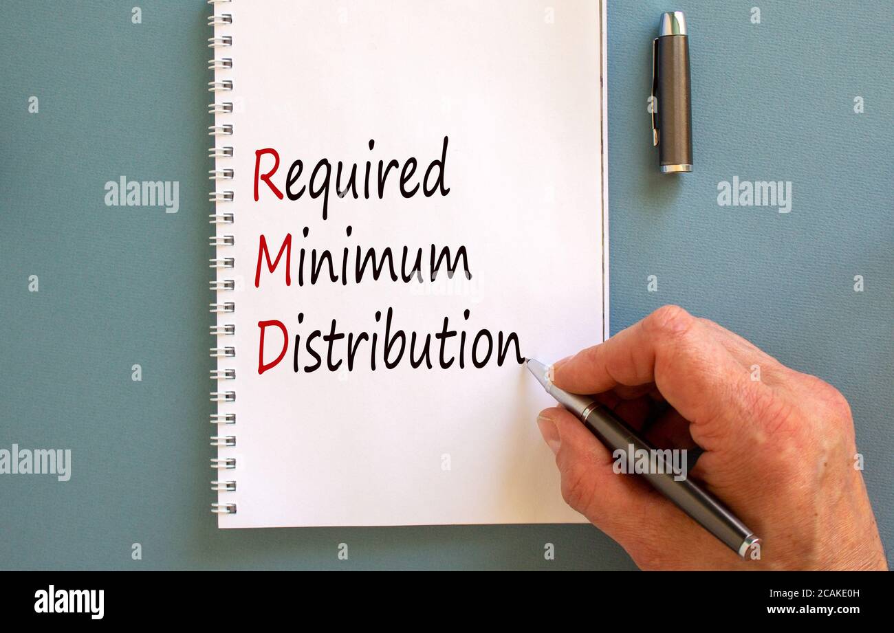 Male hand writing 'required minimum distribution' on white note ...