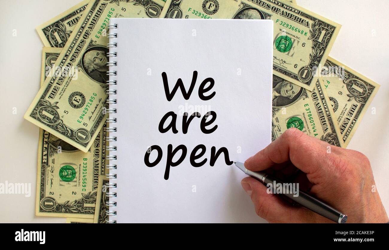 Male hand writing 'we are open' on white note, on white background ...