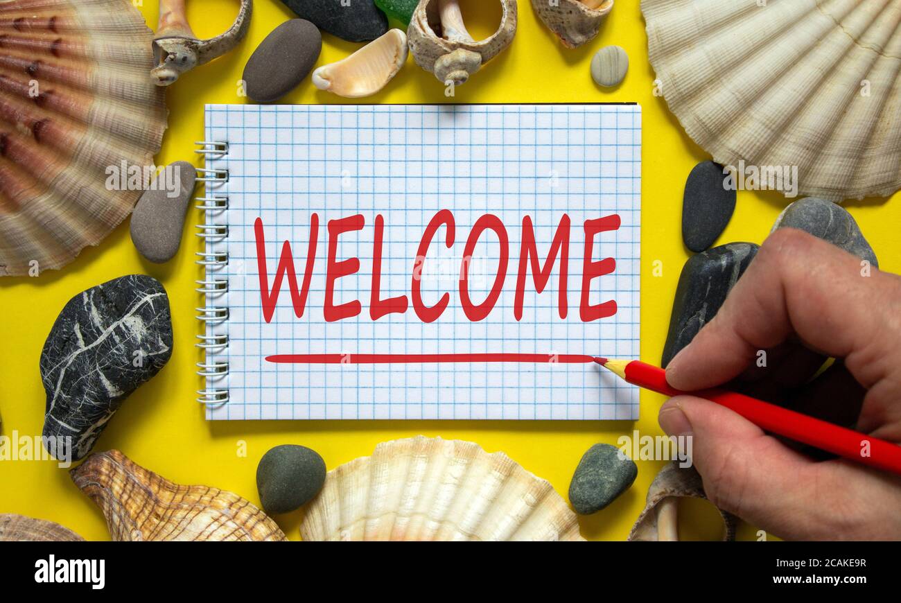 Male hand with red pencil writing 'welcome' on white note. Beautiful ...