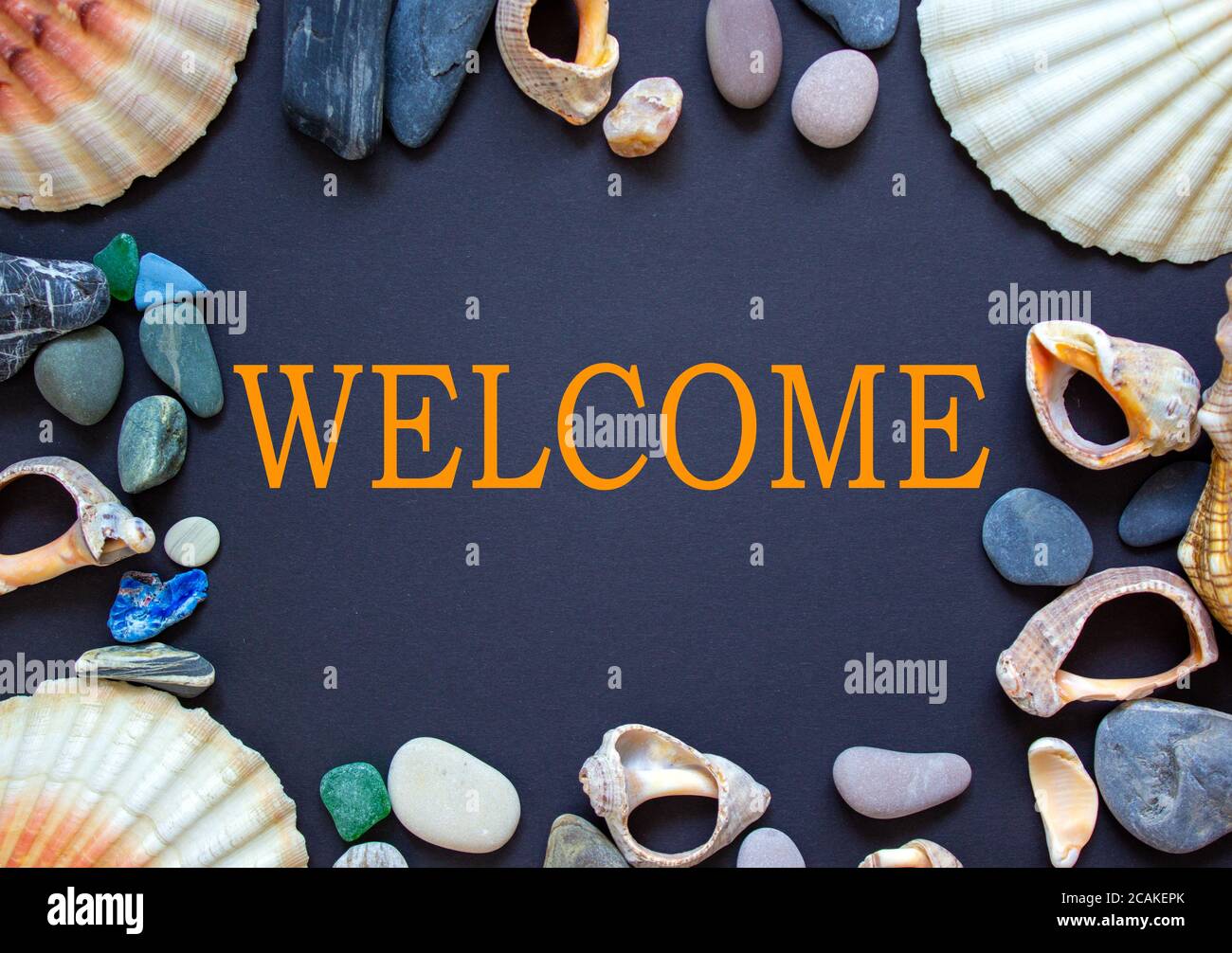 Word 'welcome' on a beautiful black background. Sea stones and ...