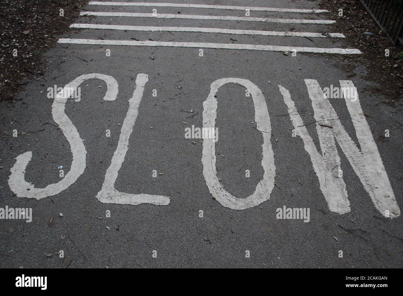 Worded marking SLOW painted on the road to warn drivers to slow down ... Worded marking SLOW painted on the road to warn drivers to slow down ...