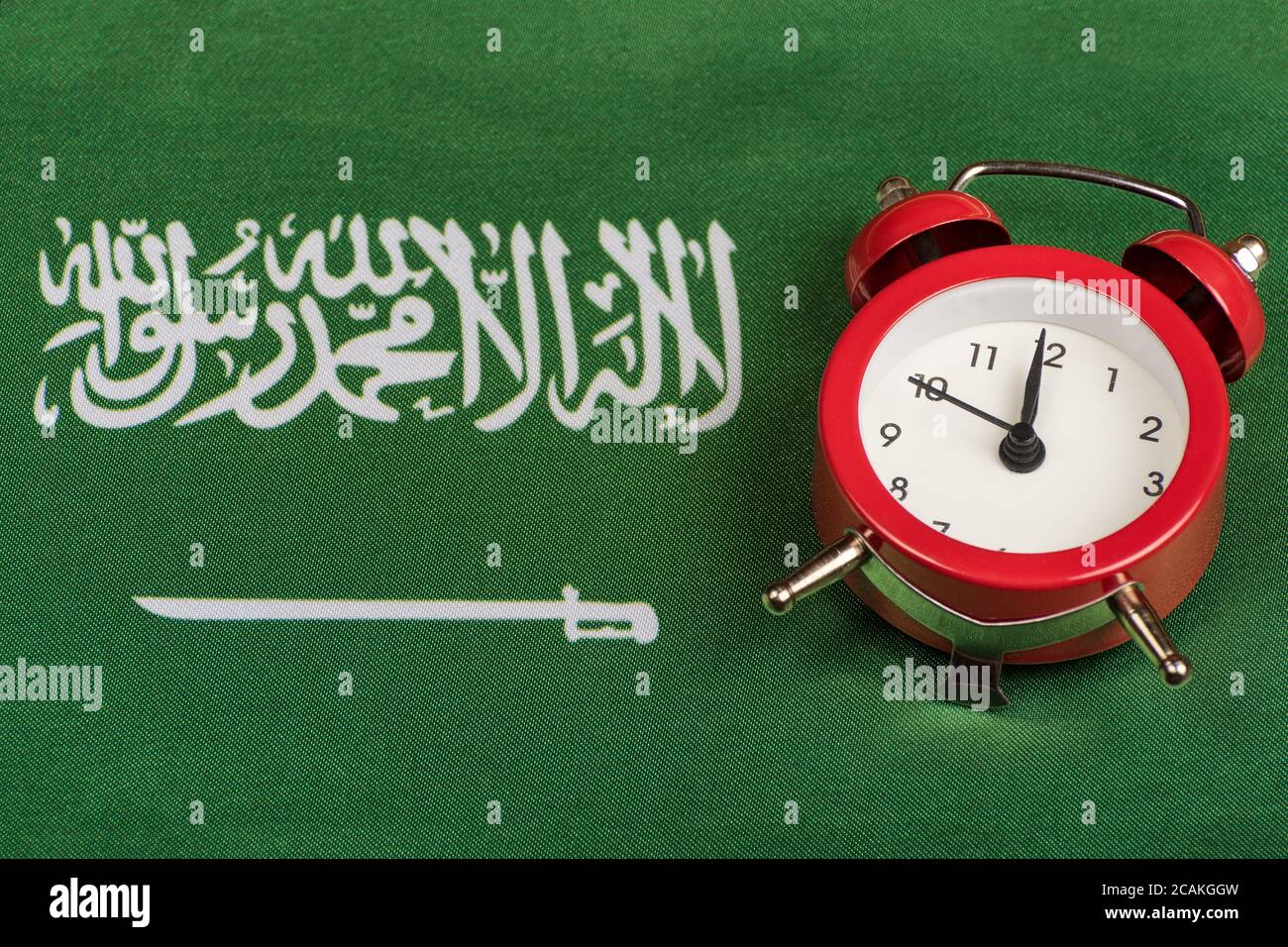 Saudi Arabia flag and vintage alarm clock close up. Green flag with ...