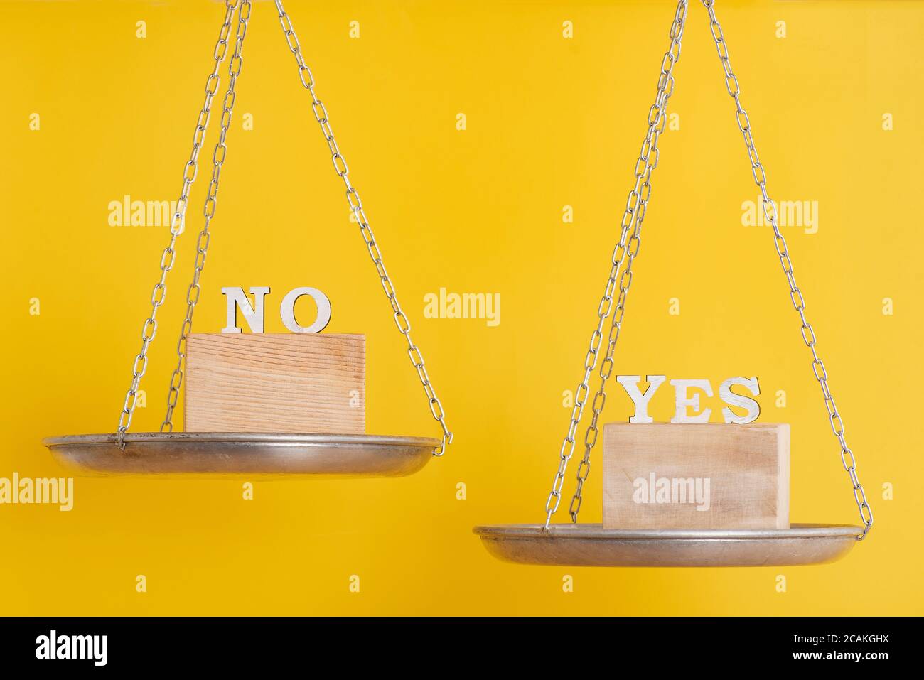 Yes vs No. Choice concept. Balance scales on yellow background. Close ...