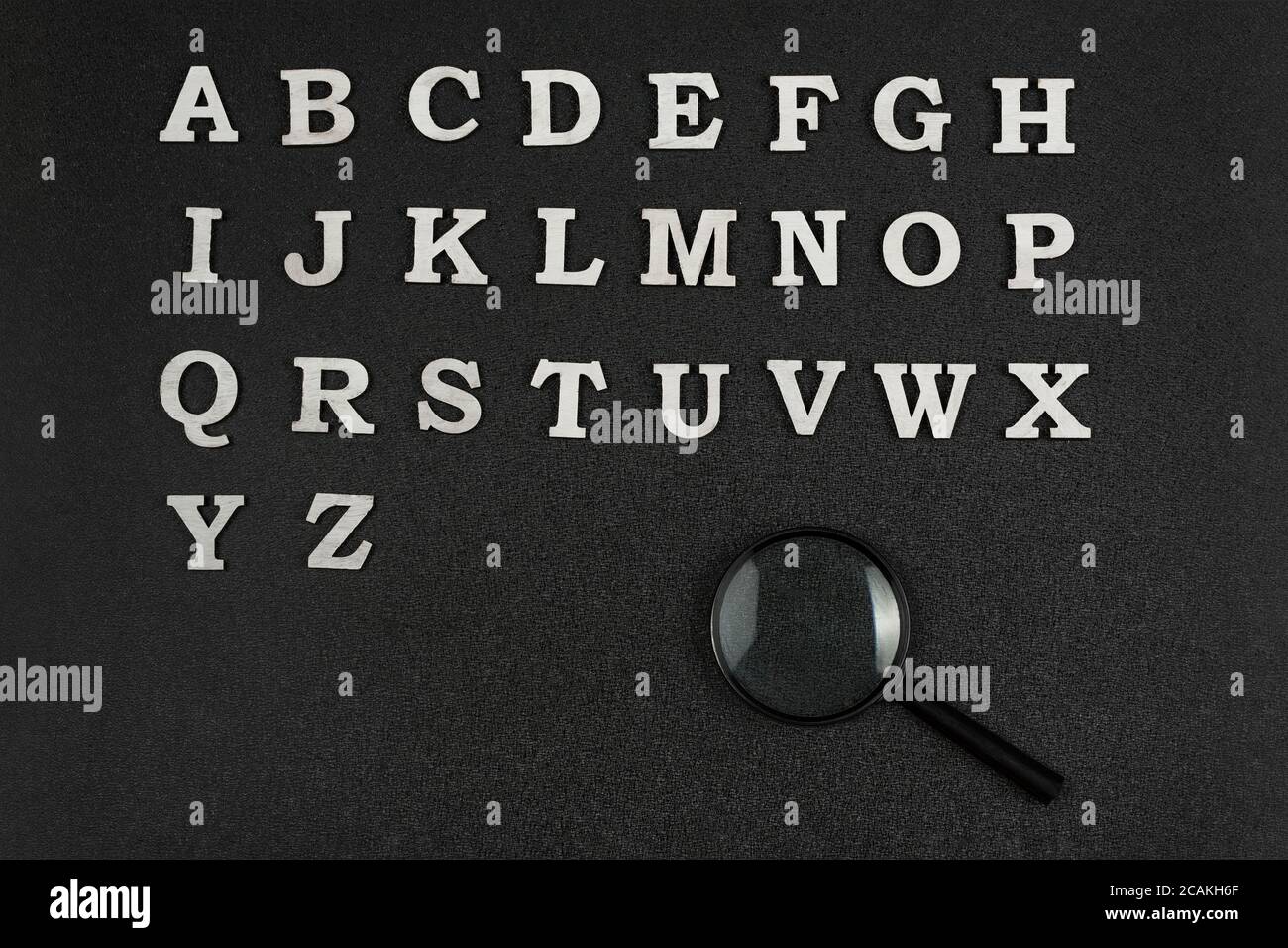 English alphabet composed of letters on dark background and magnifying ...