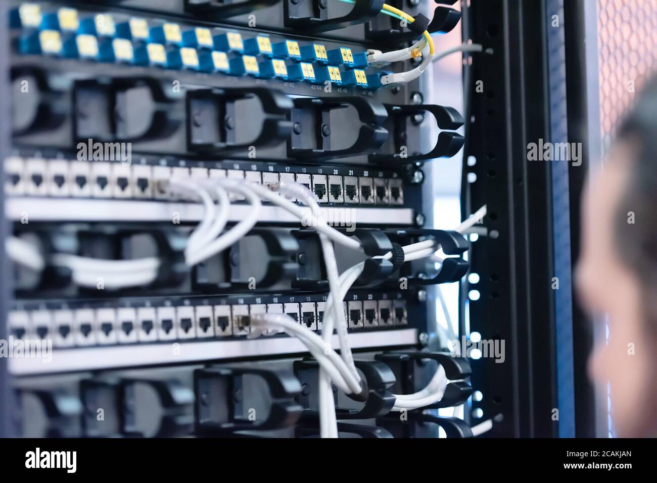 An Expert Engeneer in datacenter server room connecting cables in ...